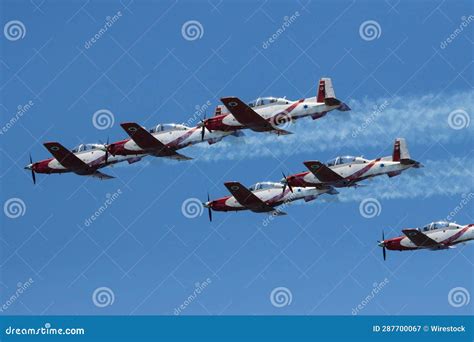 Planes In Formation Soaring Through The Sky Emitting Plumes Of Vapour