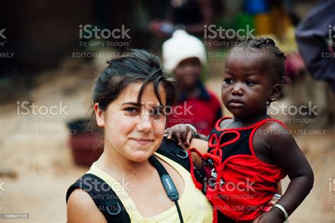 White Caucasian Young Woman Plays With Black African People In A Rural