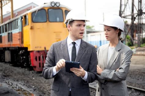 Young Caucasian Engineer Man And Woman In Suit Checking Train With