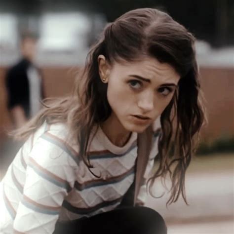 A Young Woman Riding A Skateboard Down A Street