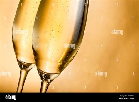 Flutes Of Champagne With Golden Bubbles Against Golden Background Stock