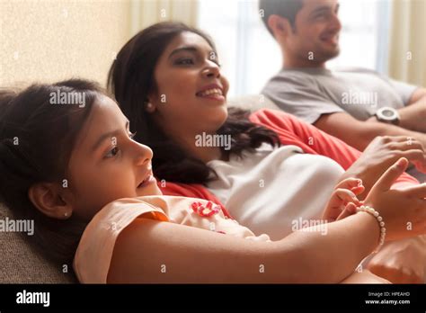 Madre Padre E Figlia Seduti Sul Divano E Guardare La Tv Foto Stock Alamy