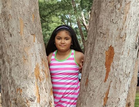 Premium Photo Portrait Of Girl Standing Against Tree Trunks At Park