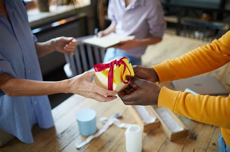 공 방에서 종이 선물 상자를 조정 하는 인식 할 수 없는 장인의 클로즈업 검은 남자에 빨간 리본으로 노란 상자를 주는 여자 선물에 대한 스톡 사진 및 기타 이미지 Istock