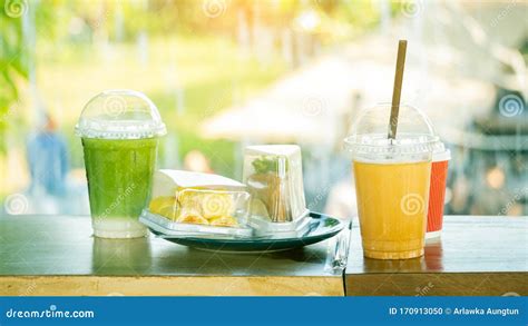 2 Glasses Of Iced Tea And 2 Cakes On The Table The Background Stock