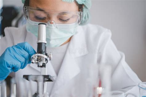 Female Medical Researcher Looking At A Microscope In A Medical