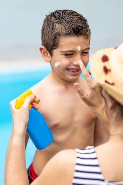 Premium Photo Mother Aplying Sunscreen To Her Son On A Summer Day