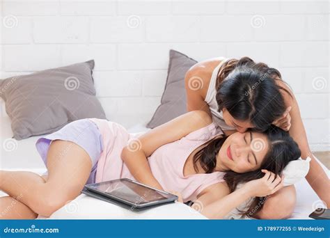 Asian Lesbian Couple Kissing On Bed In Morning At Cozy Home Stock Image