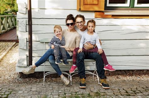 Buen Retrato De Una Alegre Familia Posando Frente A La Casa Imagen De Archivo Imagen De