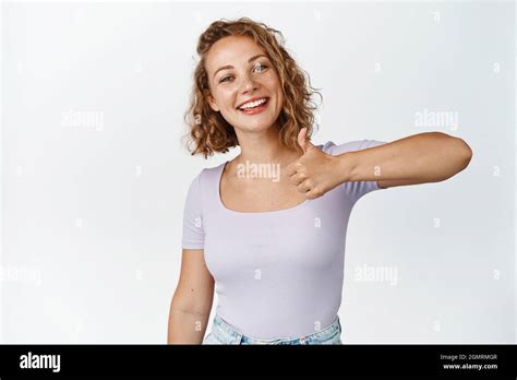 Smiling Blond Girl Shows Thumbs Up With Satisfied Face Expression