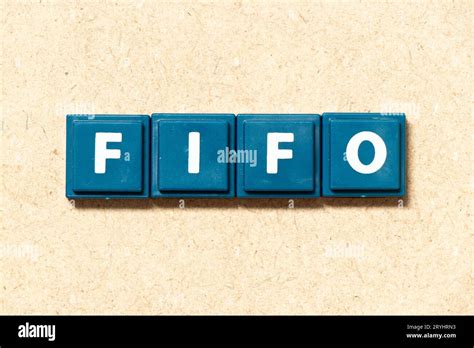 Tile Alphabet Letter In Word FIFO Abbreviation Of First In First Out On Wood Background Stock