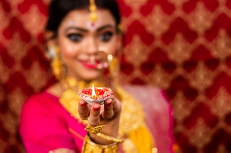 디왈리를 계기로 꽃을 배경으로 오일 램프 조명이나 디야를 들고 전통 사리 드레스를 입은 아름다운 젊은 인도 여성 Onam에 대한 스톡 사진 및 기타 이미지 Istock