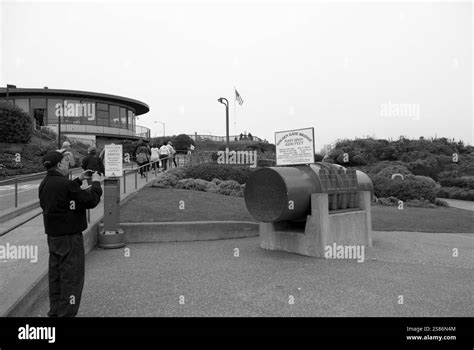 Caucasian Man Snapping Picture Of Span Of Cable Display At Entrance To