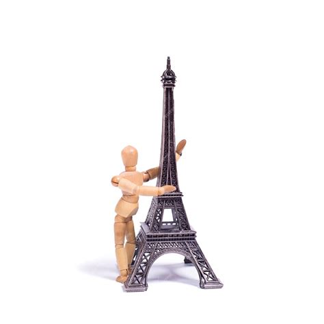 Premium Photo A Figurine Is Leaning Against A Small Eiffel Tower