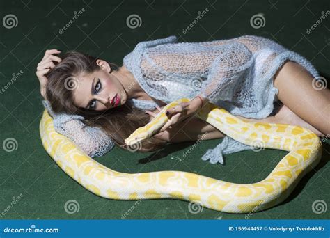Young Woman Posing With Albino Python Against Green Background Stock