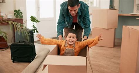 Father Push Boy And Box In New Home For Games Car Or Airplane With