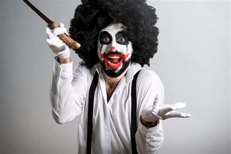 Premium Photo Killer Clown With Knife Making Surprise Gesture On