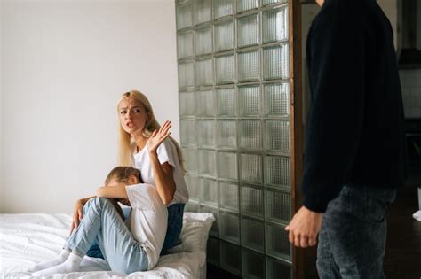 Portrait Of Scared Mother And Daughter Hugging Each Other Sitting On