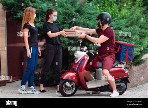 Two Womans Pick Up Delivery Food Box From Delivery Rider With Scooter