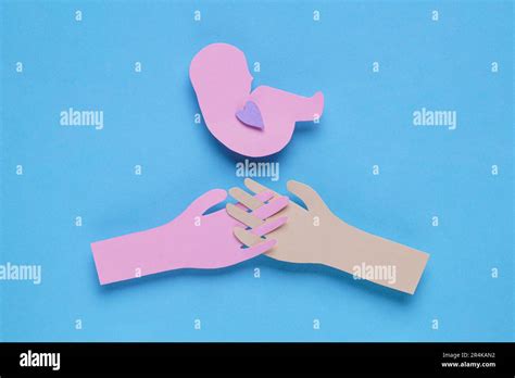 Womans Health Newborn Paper Figure And Hands On Light Blue Background