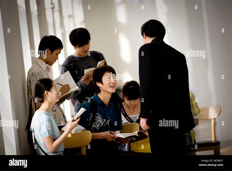 Teenage Students Talking With Their Mid Adult Teacher In A Classroom