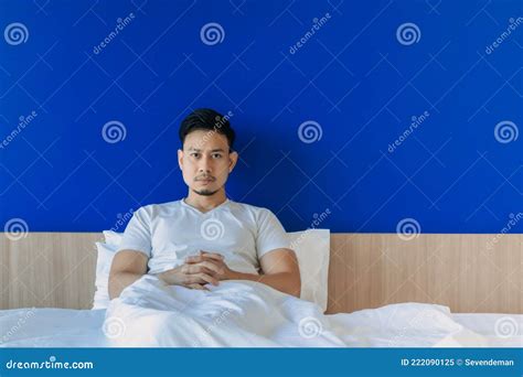 Serious And Grumpy Man Wake Up On The Bed On Blue Space Background
