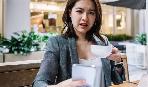 Baffled Young Asian Woman With Coffee Cup And Smartphone Stock Image Image Of Gadget Female