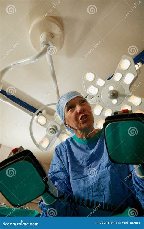 Clear A Surgeon Using A Defibrillator During Surgery Stock Image