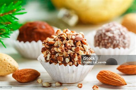 수 제 초콜릿 트 뤼 플과 아몬드 코코넛 비스킷 빵 전나무 지점과 축제 장난감 테이블에 흰 접시에 공 크리스마스와 새 해