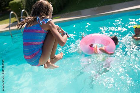 Fotografia Do Stock Back View Of Girl In Swimsuit Jumping Into