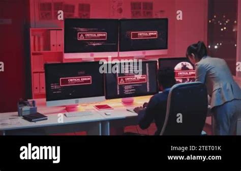 Rear View Of Two Young Diverse Cyber Security Specialists Fixing