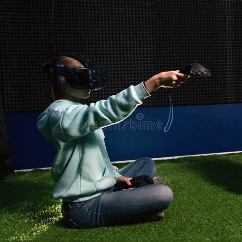 Young Girl Wearing Virtual Reality Goggles Sitting On Floor Using