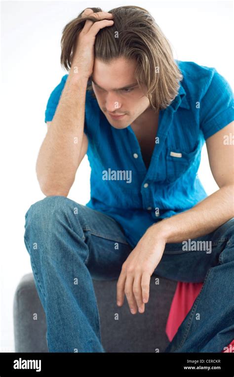 Brunette Male With Long Hair Sitting With Elbow Resting On Knee Head