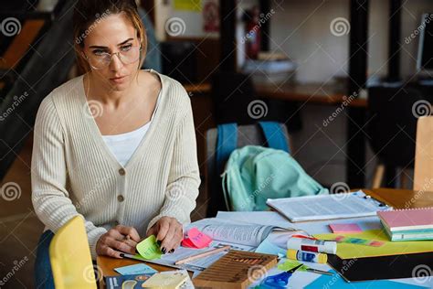 Female School Teacher Preparing For Class While Sitting In Classroom