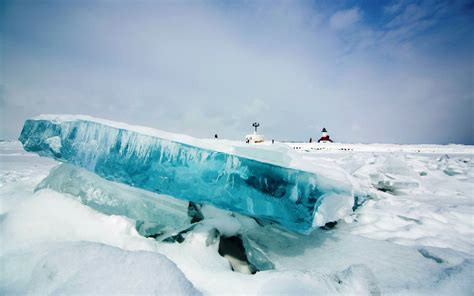 Large Blue Ice Chunk On A Frozen Landscape With Lighthouses Hd