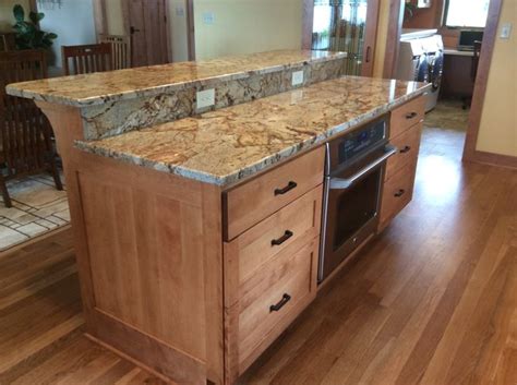Raised Bar Kitchen Island With Granite Countertops And Wooden Cabinets