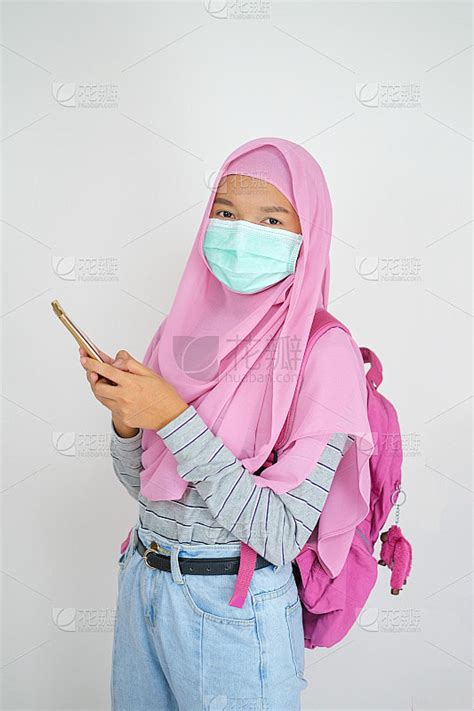 学生使用智能手机戴上口罩穆斯林女孩
