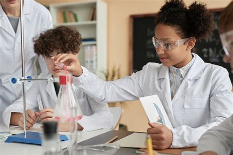 Side View Smiling Black Schoolgirl Doing Science Experiment In School Side View Smiling Black Schoolgirl Doing Science Experiment In School