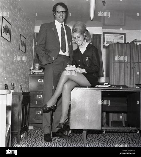 1970s Historical A Secretary Wearing A Mini Shirt Sits On The Edge Of