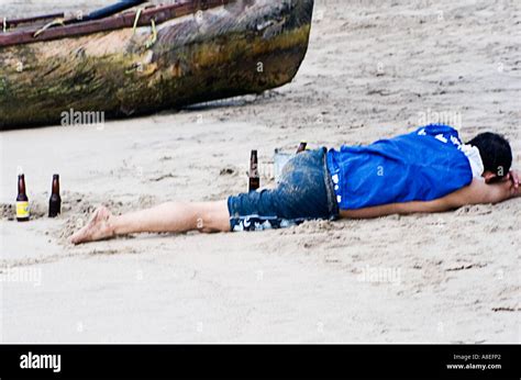 A Drunk Tourist Passed Out On The Beach Near A Canoe In Puerto Vallarta