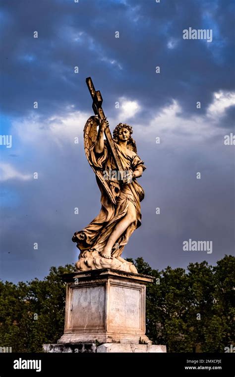 A Vertical Shot Of A Marble Angel Statue Holding The Cross On The St