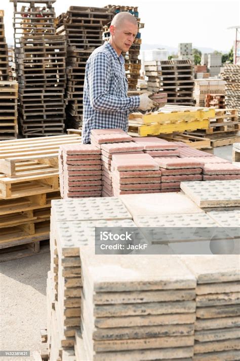 작업자는 건축 자재 창고의 팔레트에 포장 슬래브를 배치합니다 30 34세에 대한 스톡 사진 및 기타 이미지 30 34세