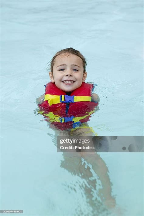 Girl Wearing Inflatable Life Jacket In Swimming Pool Elevated View