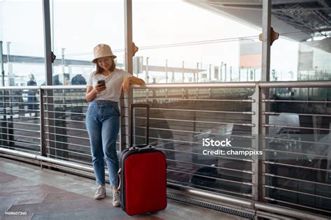 공항 개념의 여행 가방을 가진 여행자 국제 휴가 휴식 및 휴식에서 여행 여행 예약 티켓 비행을 위해 수하물과 승객을 운반하는 스마트 폰을 사용하는 어린 소녀 Brand