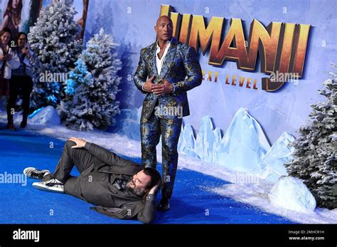 Cast Members Jack Black Laying Down And Dwayne Johnson Pose For