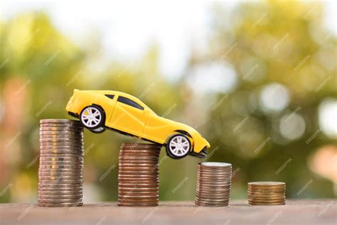 Premium Photo Yellow Toy Car On Stacked Coins At Table