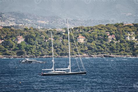 Monaco Mega Yacht And Huge Sail Boat Are In Sea At Sunny Day Island