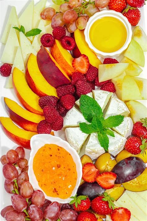 Assorted Cheese Plate With Fruits And Sauces Isolated On White