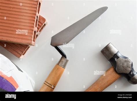Bricklayer Tools And Materials Such As Trowel Hammer Bricks And Cement Bag On White Background