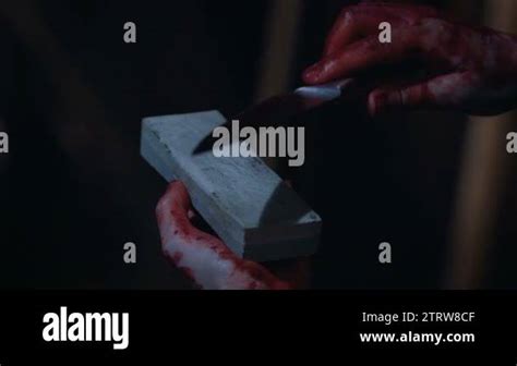 Killer With Bloody Hands Sharpening Murder Weapons Preparing To Kill